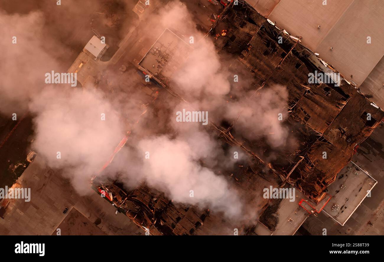 Drone shot over residential block ablaze with dense smoke billowing ...