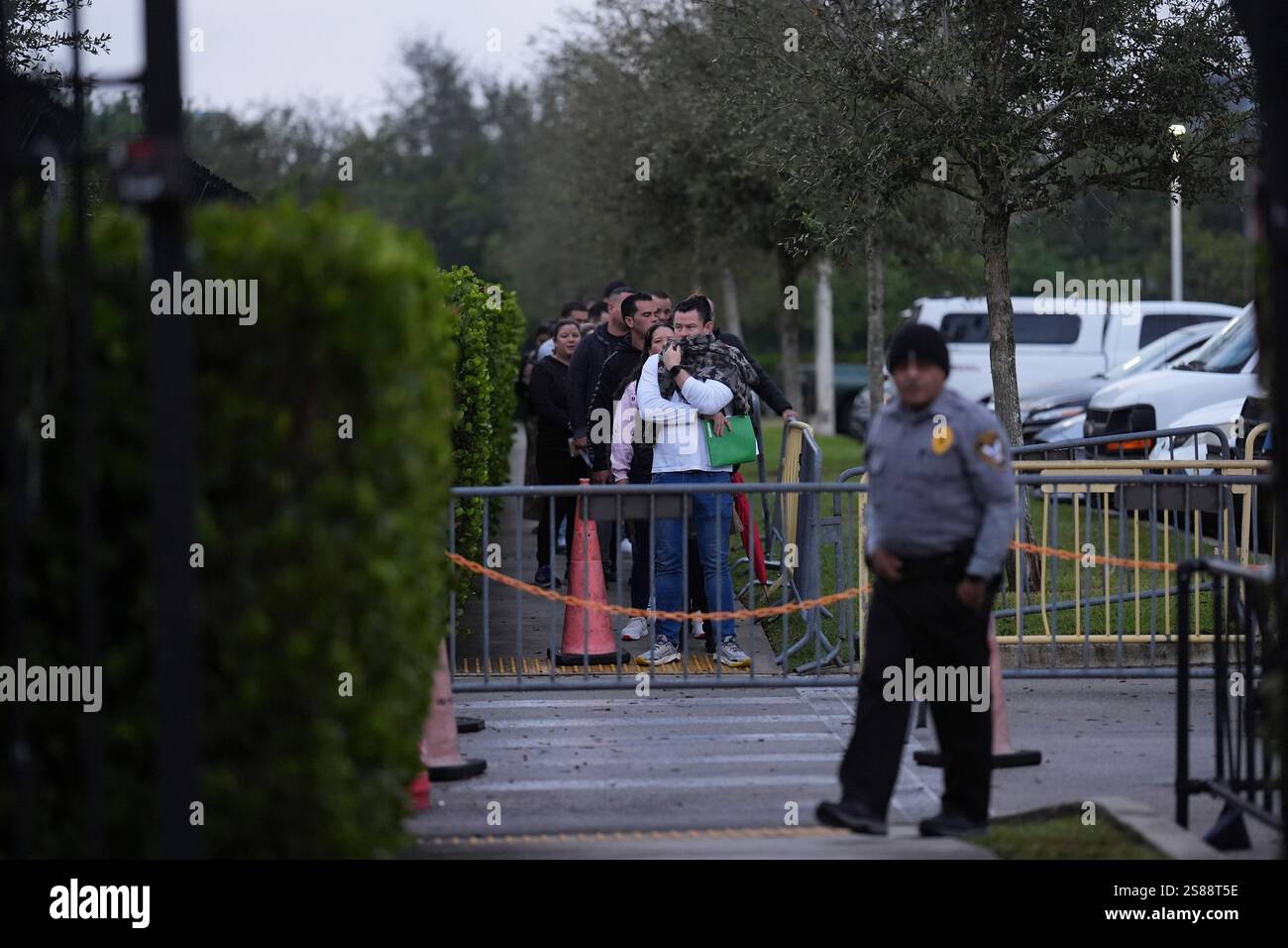Migrants wait in line for scheduled appointments to establish or ...