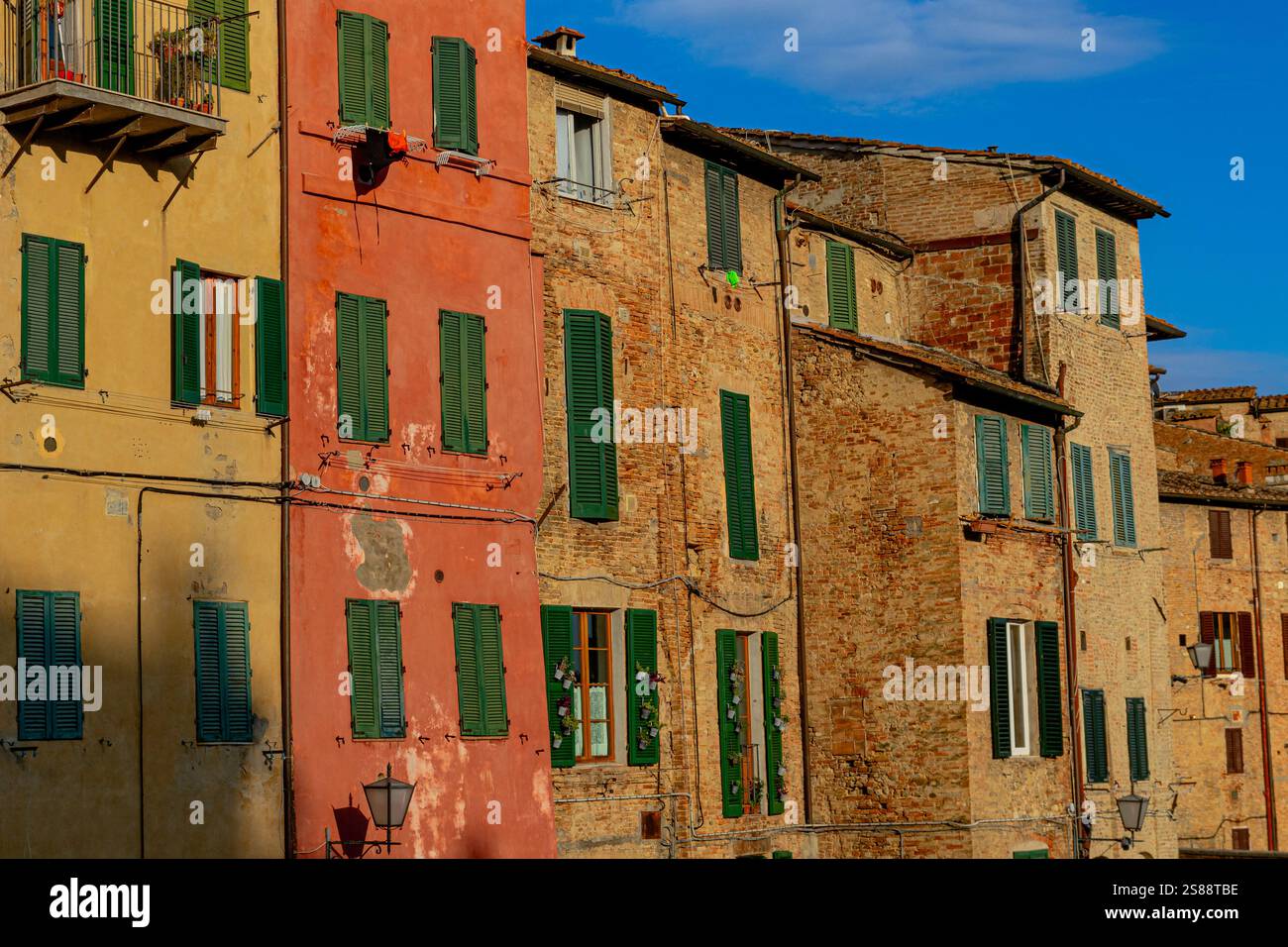 Pastel coloured stone buildings with green wooden shutters in the ...