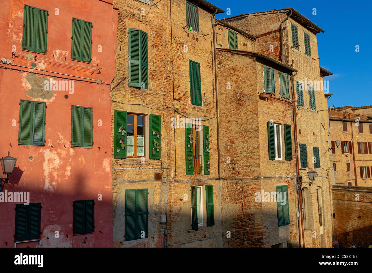 Pastel coloured stone buildings with green wooden shutters in the ...