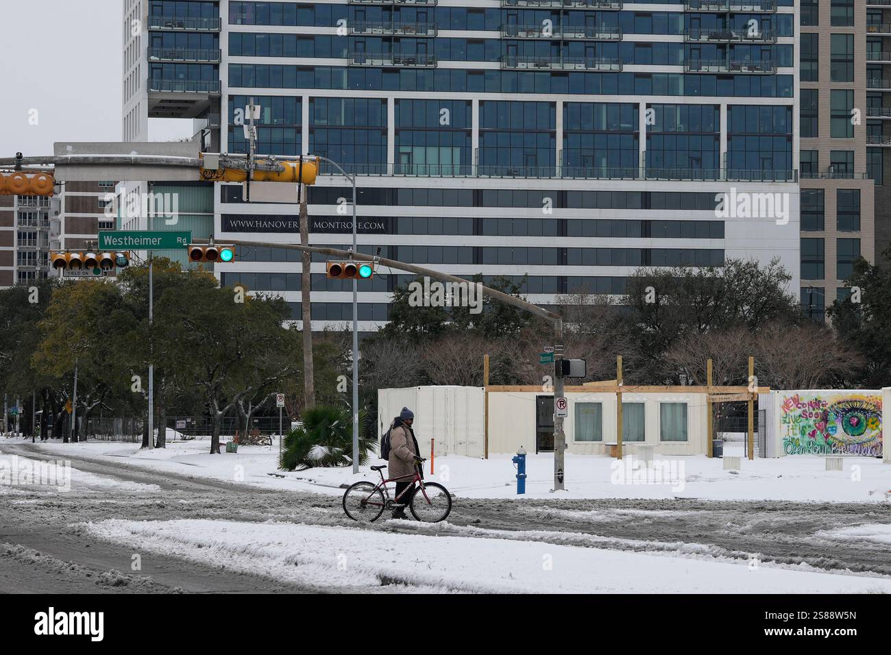 A cyclist crosses Montrose Boulevard at Westheimer Road during snow ...