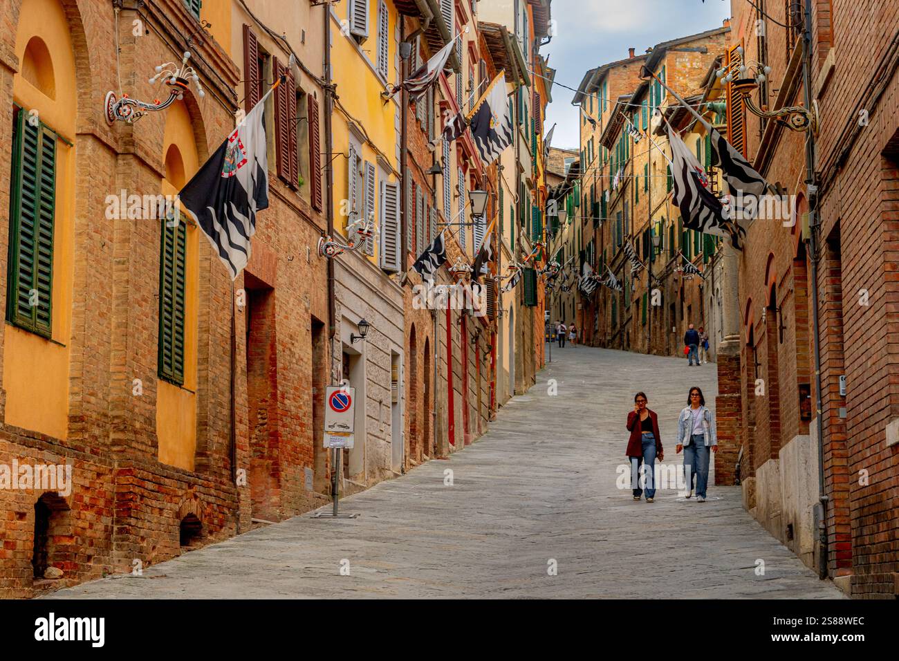 Two girls walking down Via di Vallerozzia, a steep street surrounded by ...