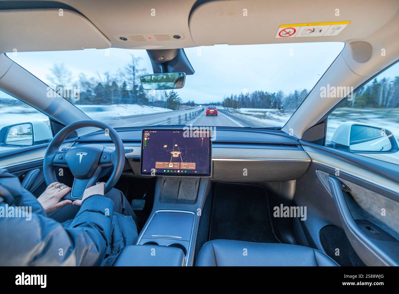 Tesla Model Y interior view with autopilot engaged on snowy highway ...