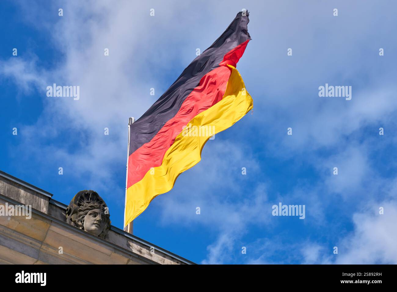 German Flag against the Sky. German flag waving in a strong breeze in ...