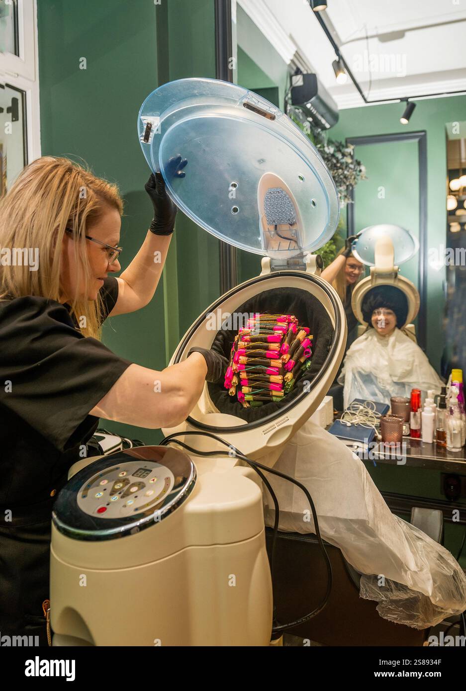 In a beauty salon, a girl is getting her hair curled Stock Photo - Alamy