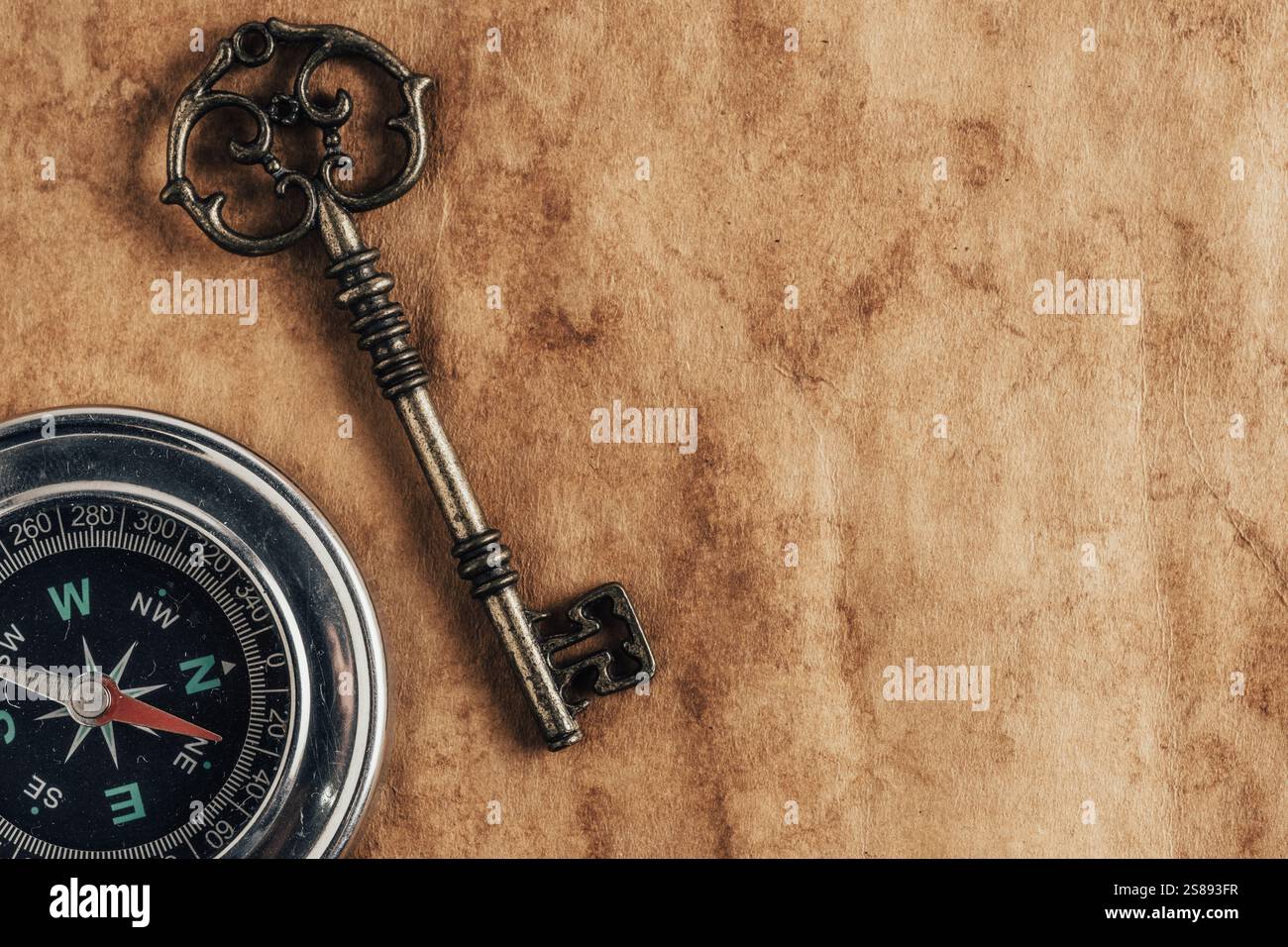 Vintage key and compass on old paper background with copy space Stock ...