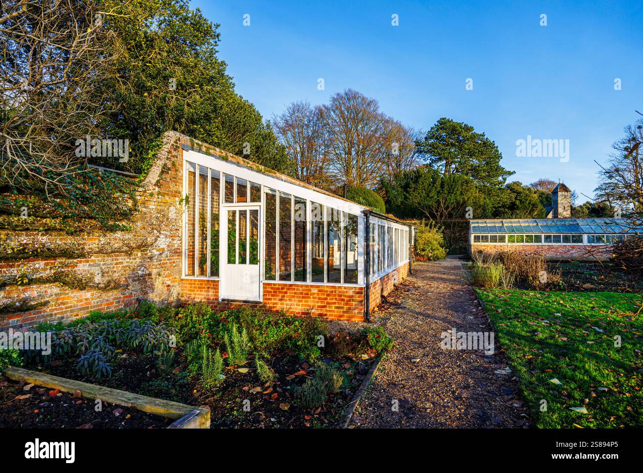 Old fashioned brick built glasshouses at golden hour in winter in the ...