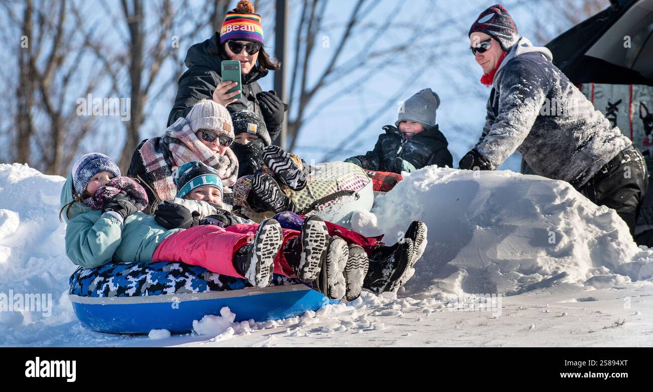 Friends and family enjoy a fun morning tubing down the hill behind ...