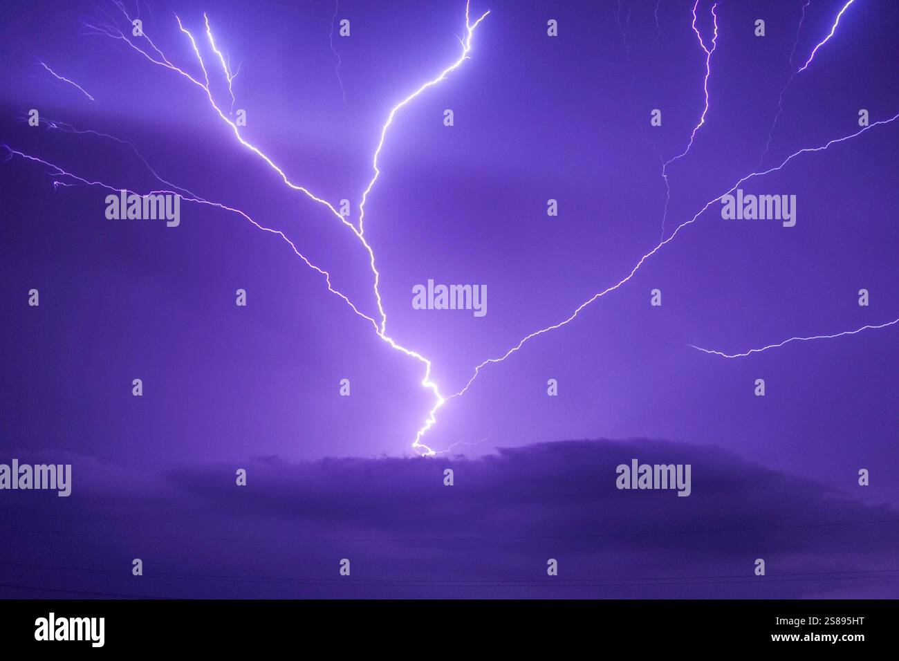 A purple sky with a lightning bolt in the middle. The sky is dark and ...