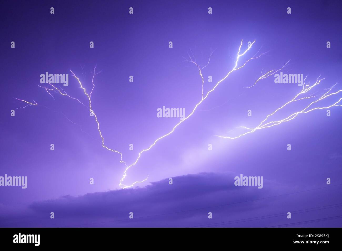 A purple sky with a lightning bolt in the middle. The sky is dark and ...