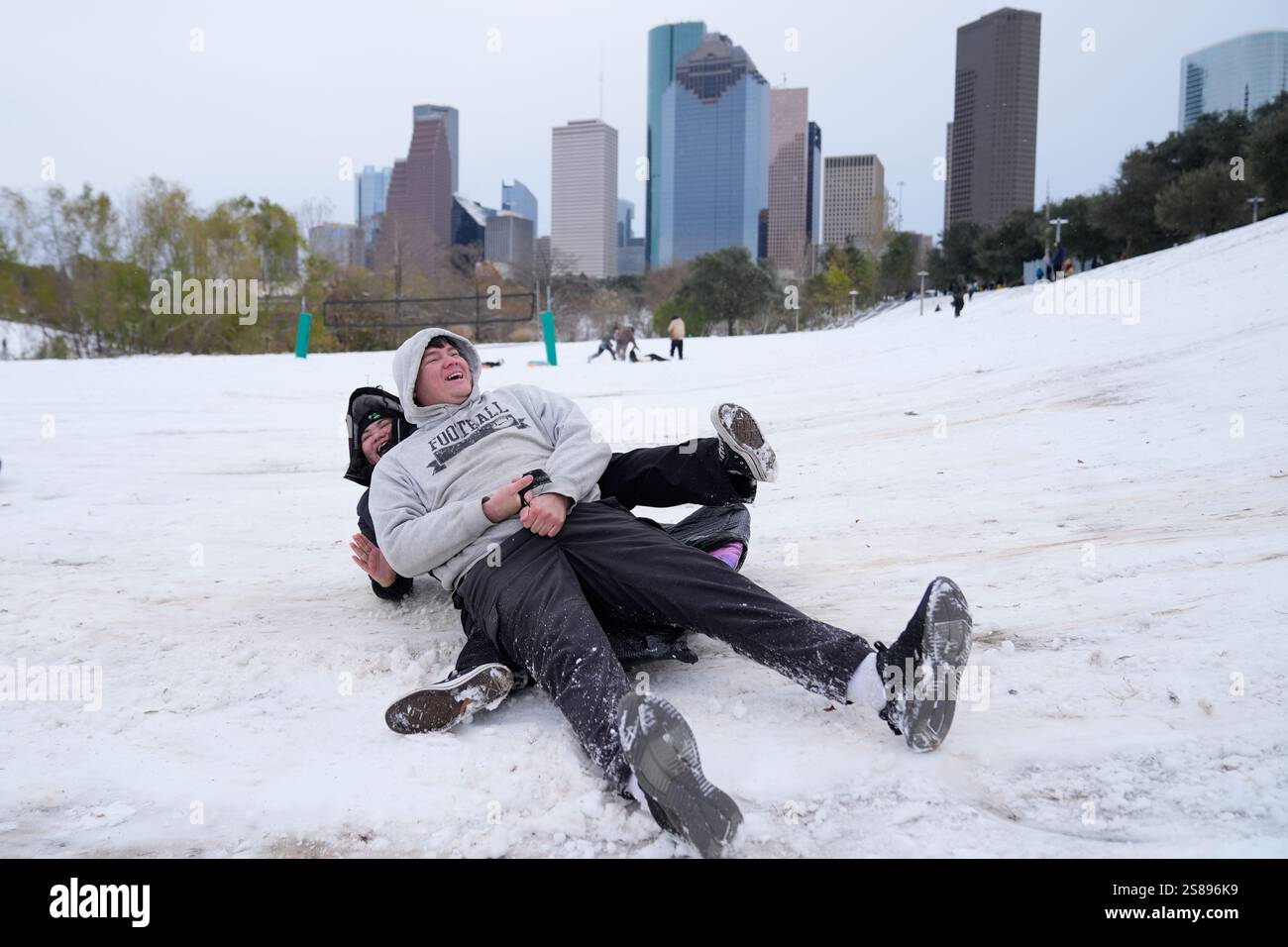 Daniel Benitez and Shayra Romero sled in a snow covered hill along ...