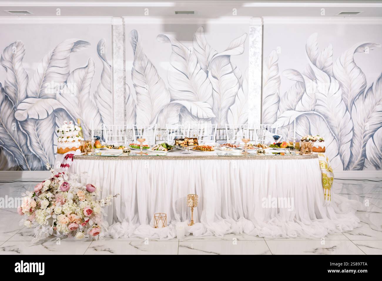 A lavishly decorated wedding reception table showcases an array of ...