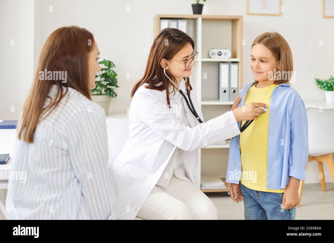 Pediatrician woman checking, stethoscope listening to child heart ...