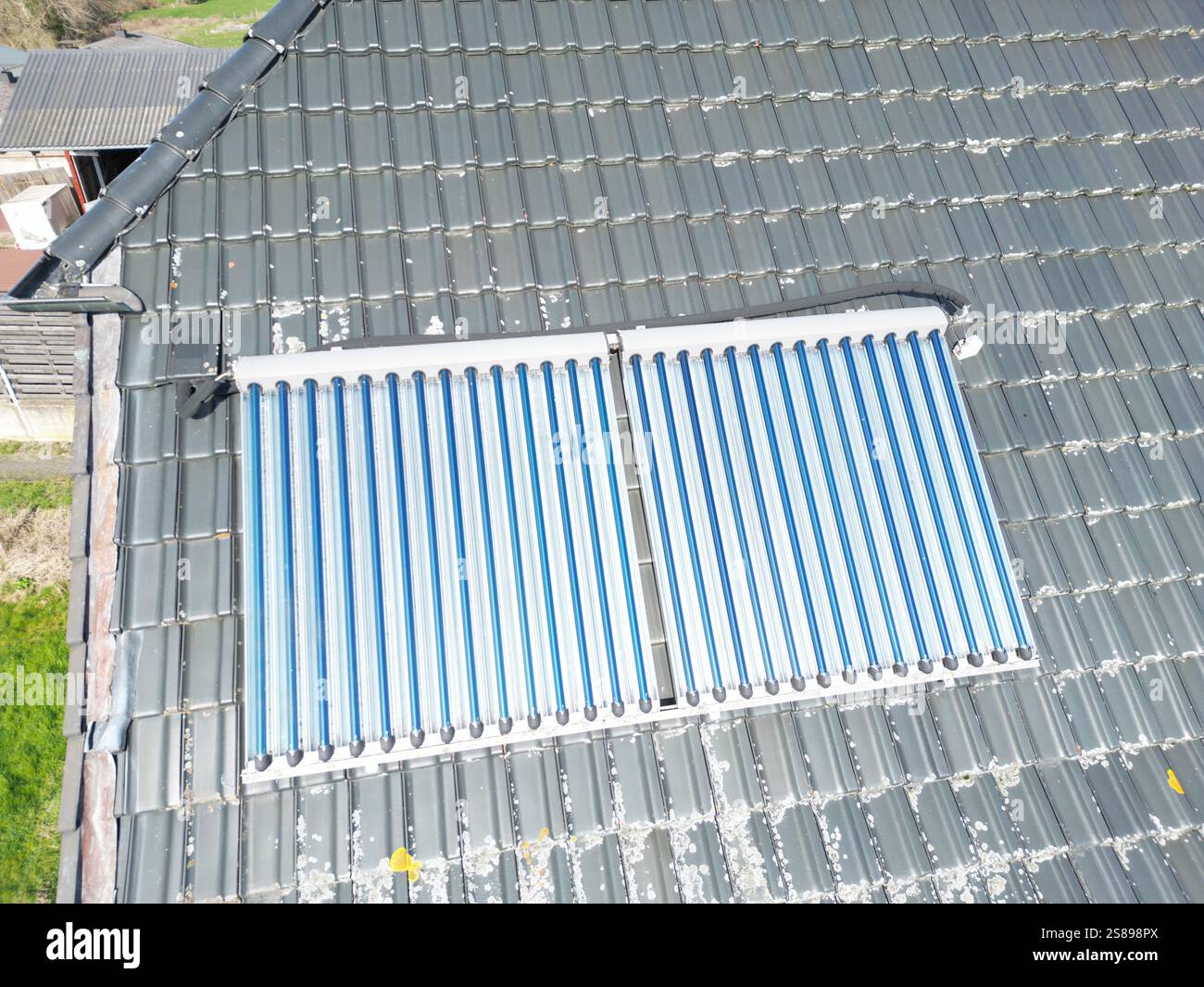 A roof with a blue and white solar panel on it. The blue and white ...