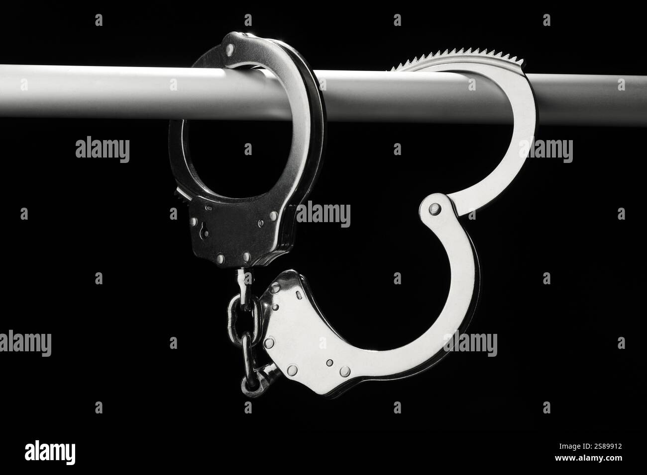 Metal chain handcuffs on pipe against black background, closeup Stock ...