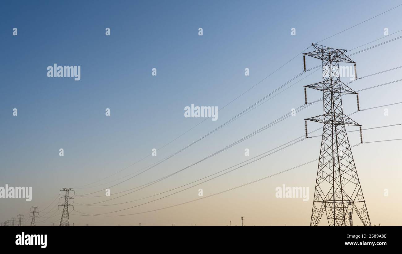 Tall electric towers stretch across the skyline, supporting high ...