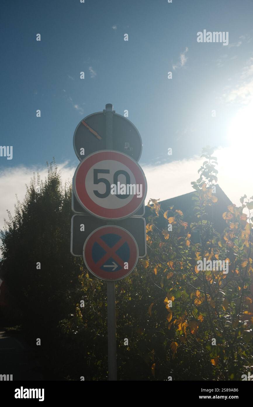 A sign with a red circle and a white number 50 on it. The sign is on a ...