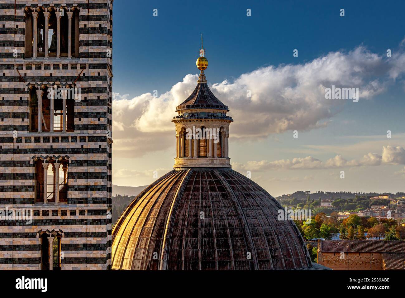 The dome and bell tower of Siena Cathedral in the late afternoon sun ...