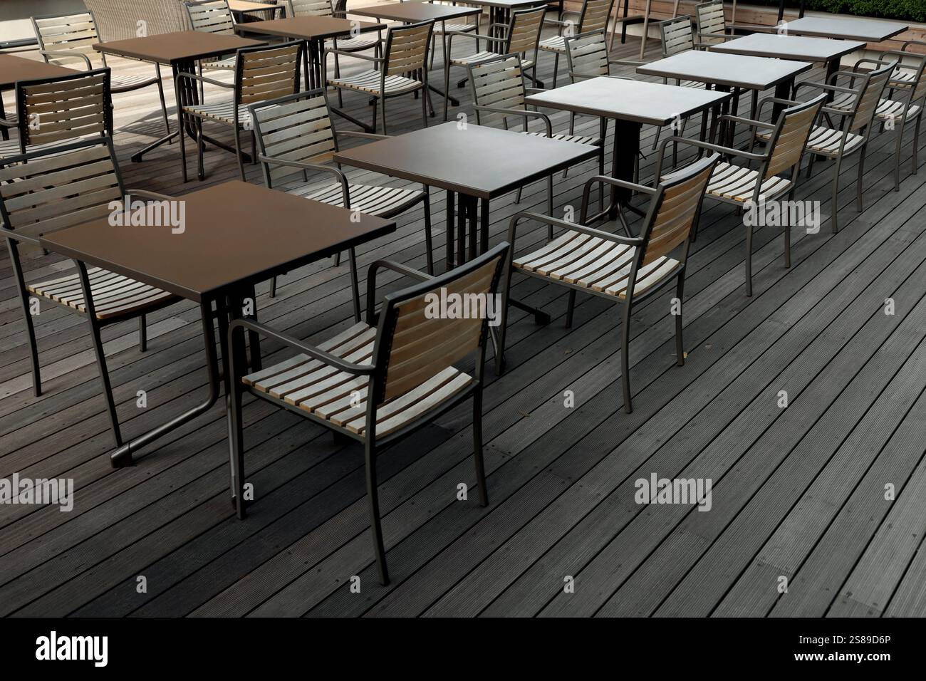 Cafe tables lined up in the wooden deck courtyard Stock Photo - Alamy