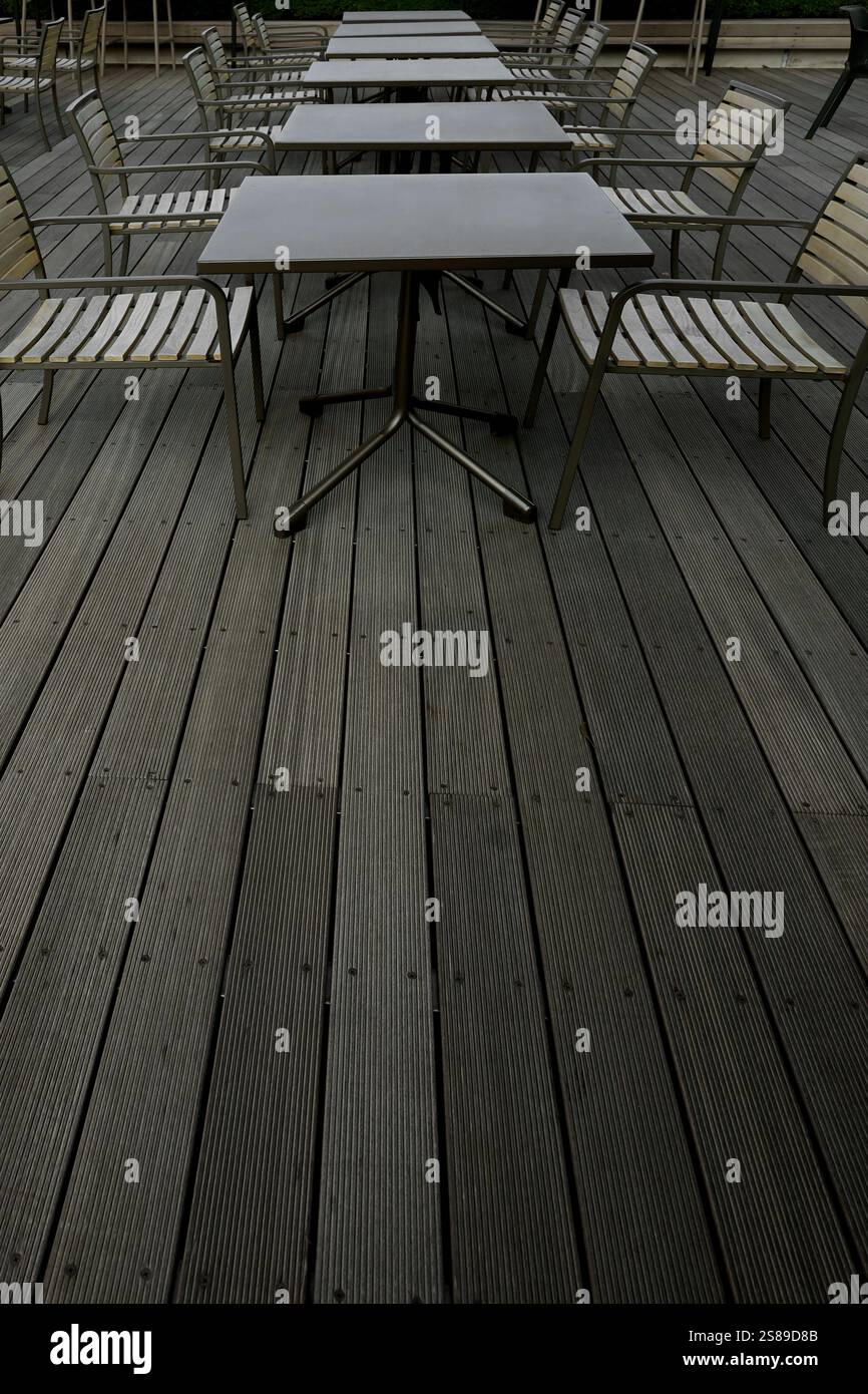 Cafe tables lined up in the wooden deck courtyard Stock Photo - Alamy