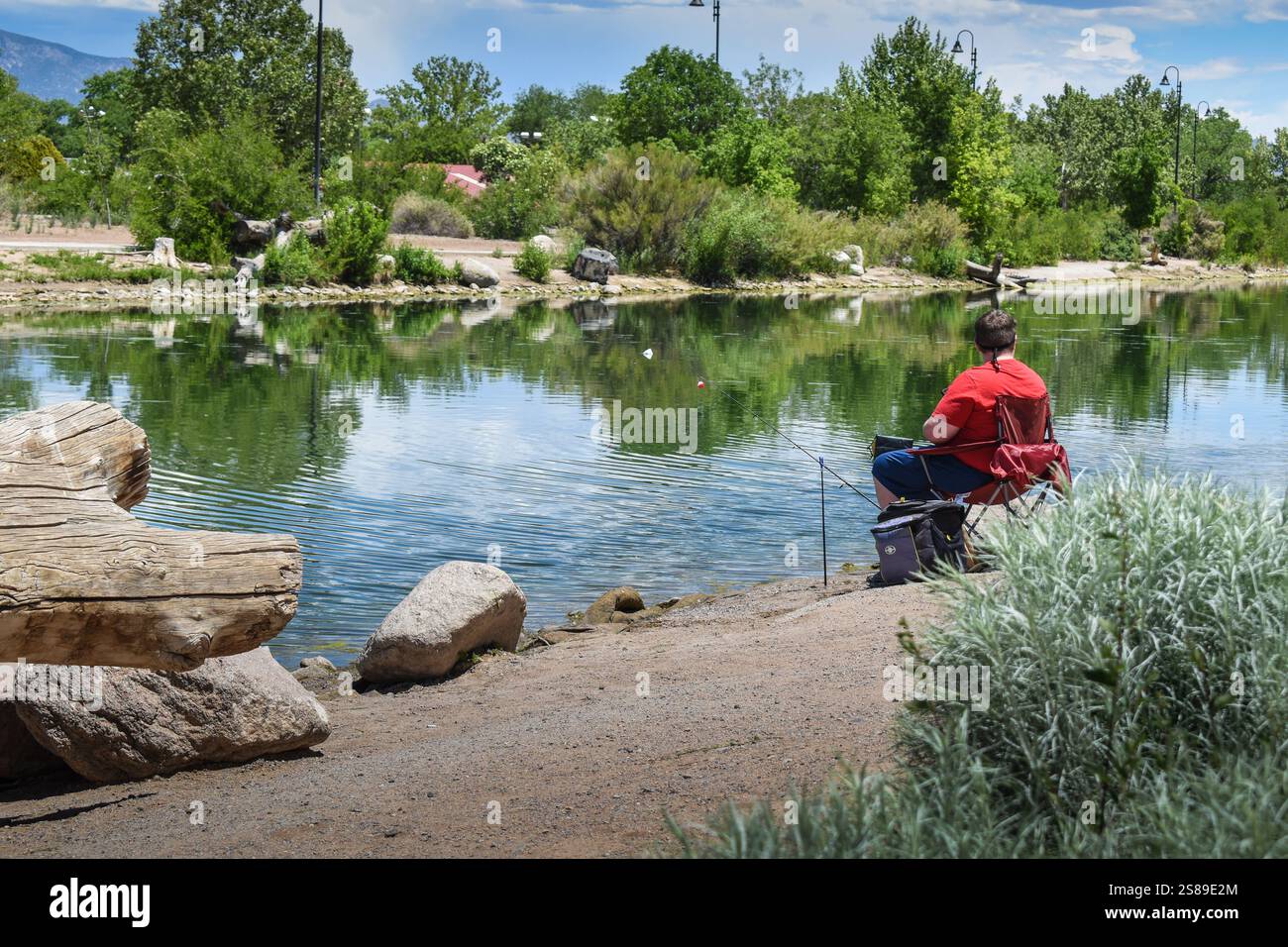 Guy in a chair enjoys fishing at Tingley Beach in Albuquerque, New ...