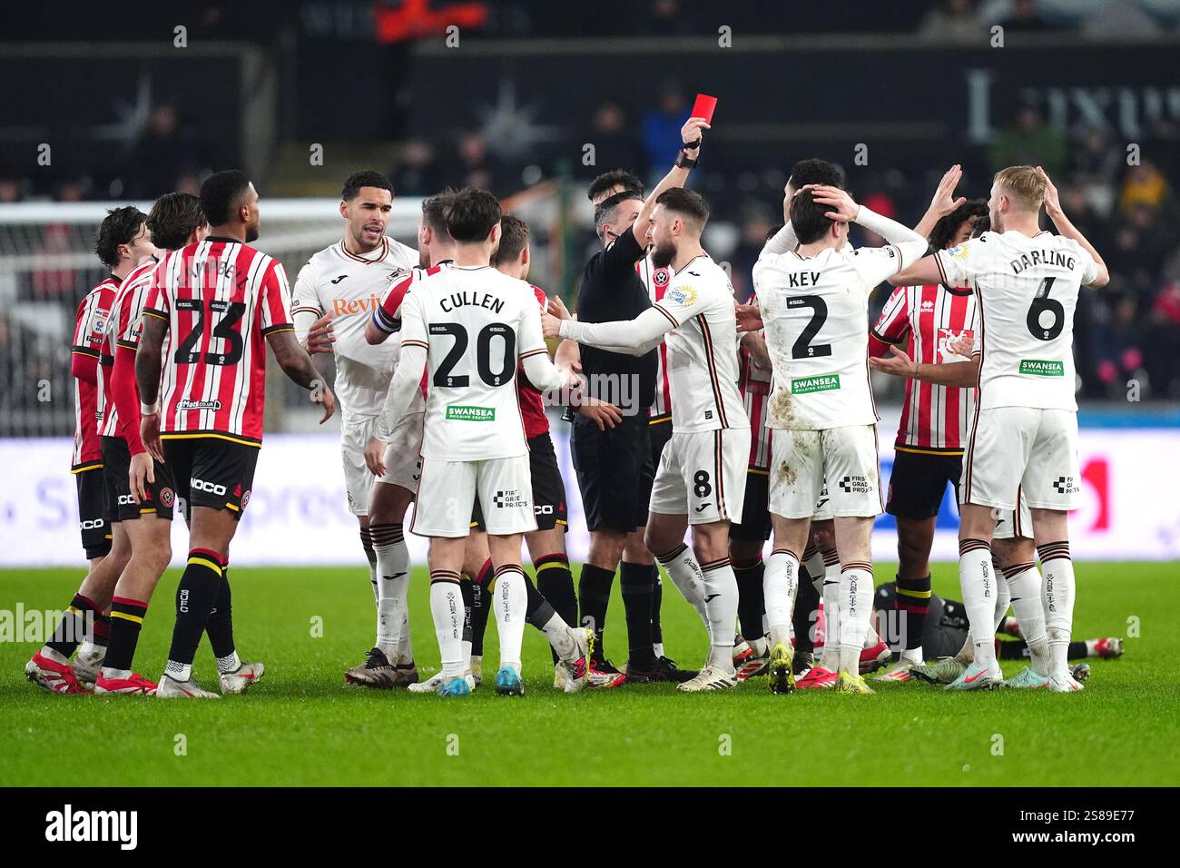 Referee Dean Whitestone shows a red card to Swansea City's Harry ...