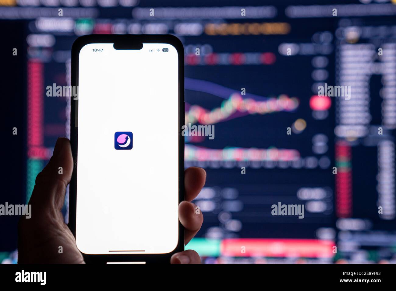 Man holding a phone with the Moonshot app logo on the screen, blurred ...