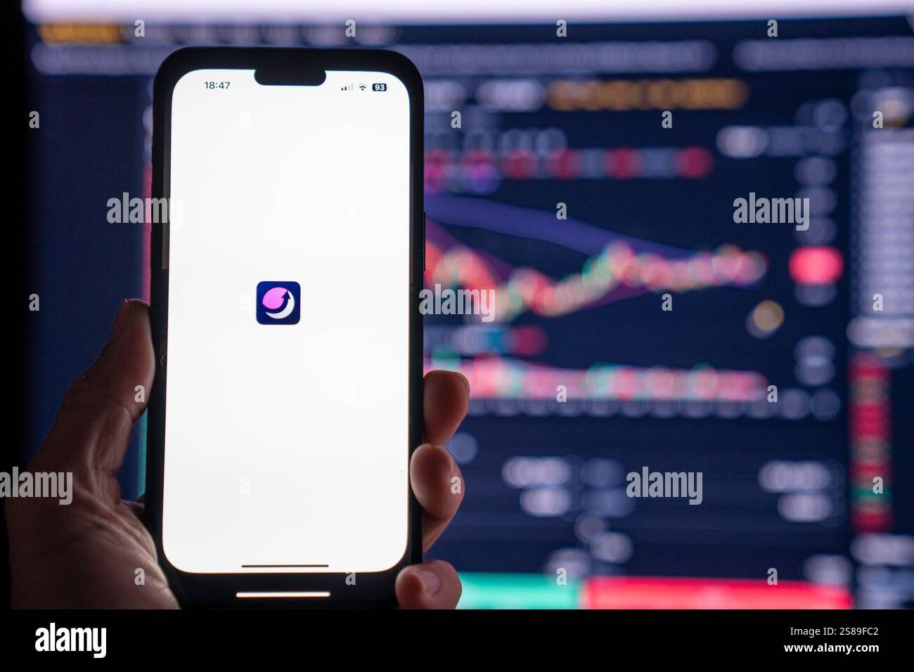 Man holding a phone with the Moonshot app logo on the screen, blurred ...