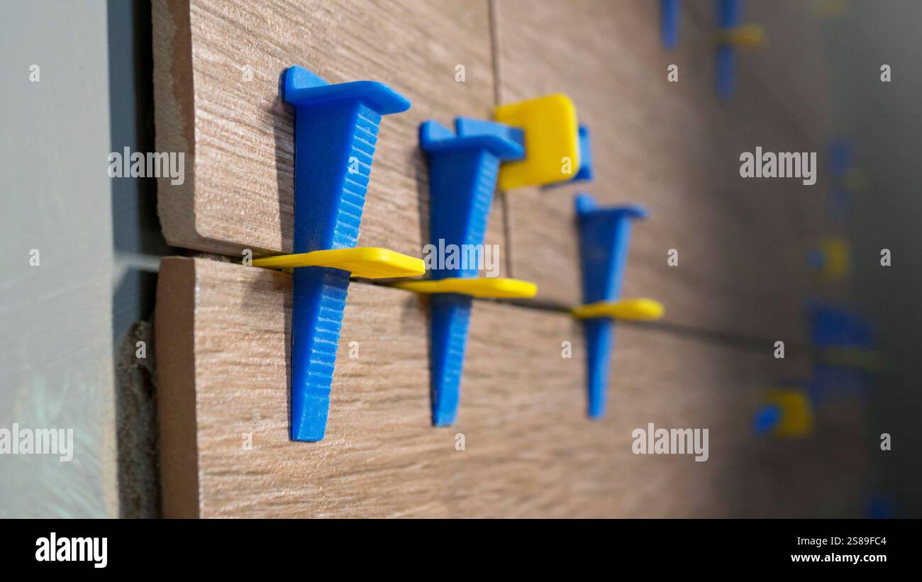 Closeup of blue and yellow plastic tile spacers used for installing ...