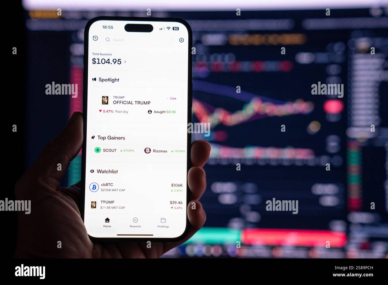 Man holding a phone displaying the OFFICIAL TRUMP meme, with a blurred ...