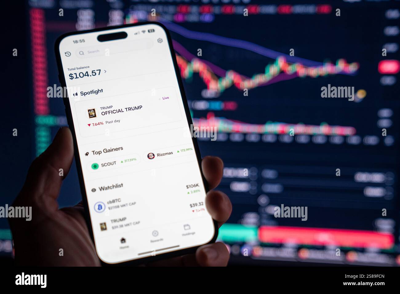 Man holding a phone displaying the OFFICIAL TRUMP meme, with a blurred ...