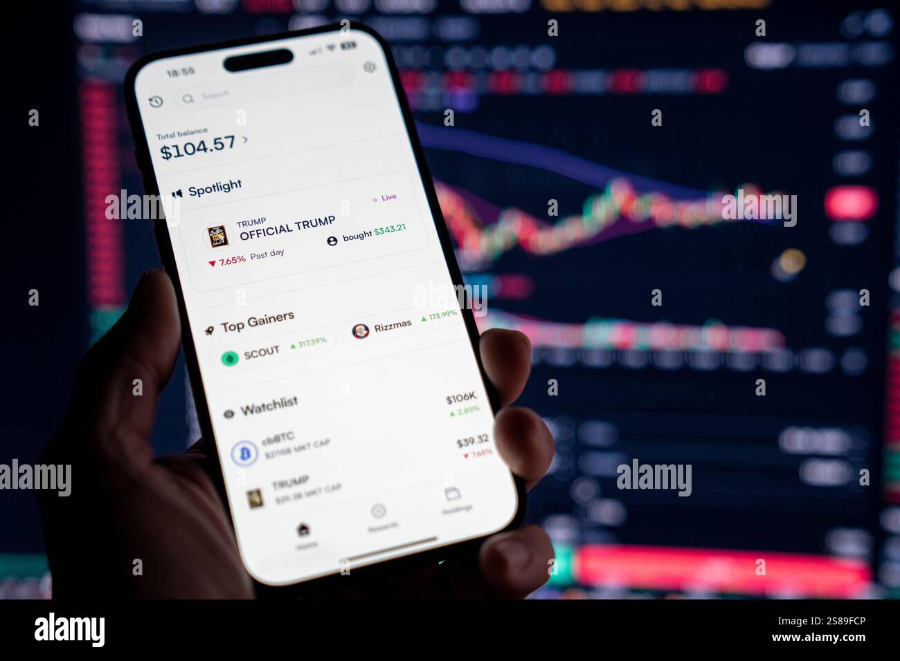 Man holding a phone displaying the OFFICIAL TRUMP meme, with a blurred ...