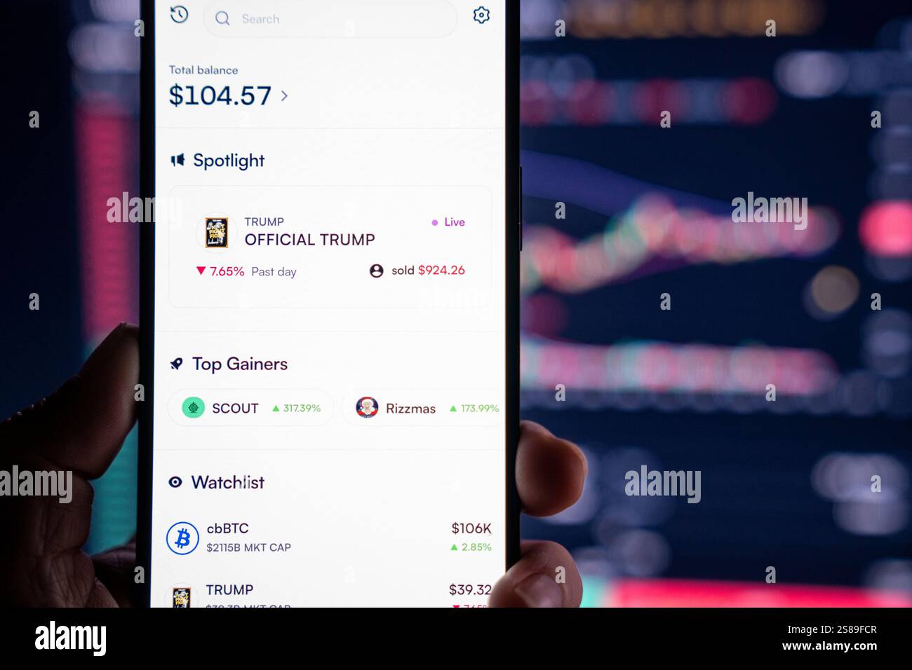Man holding a phone displaying the OFFICIAL TRUMP meme, with a blurred ...