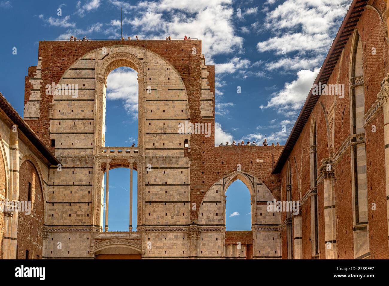People at the top of The Facciatone of Siena,the remains of the New ...