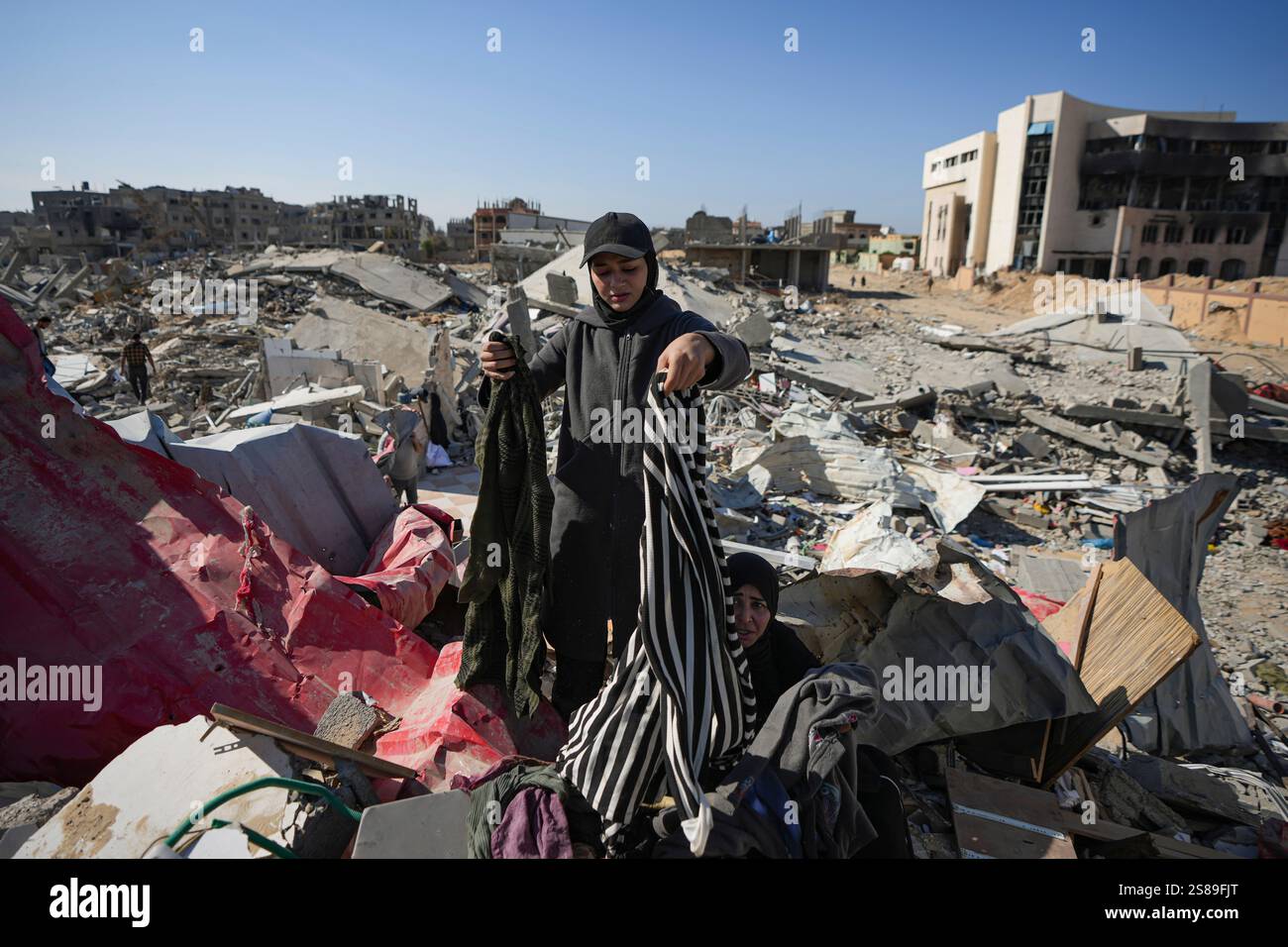 Nour Abu Al Zamar salvages items from under the rubble of her destroyed ...