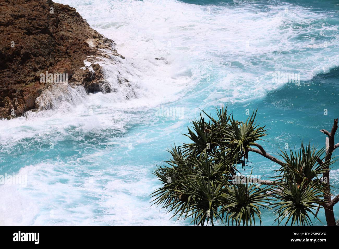 close-up blue ocean waves breaking on rocky outcrop shore Stock Photo ...
