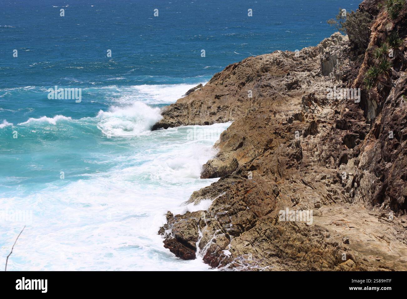 deep blue ocean water turns to white foam as waves crash onto rocky ...