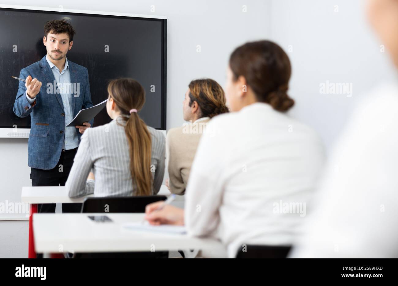 Young male teacher giving lecture to group of student Stock Photo - Alamy
