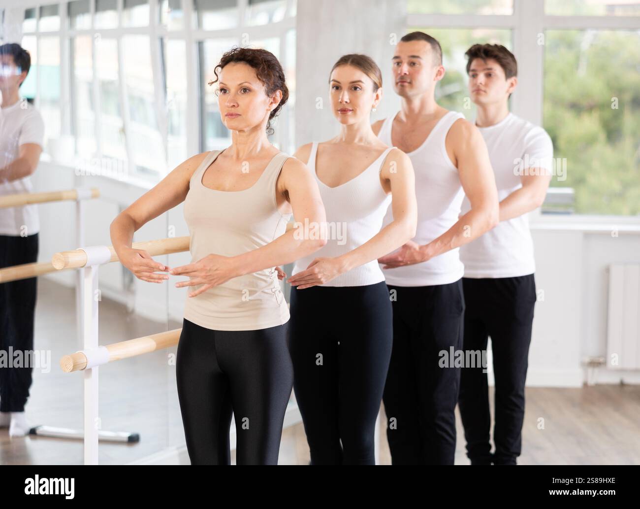 Group of dancers stand in first position at barre Stock Photo - Alamy