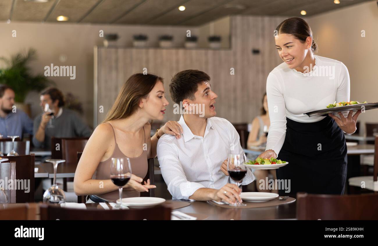 Friendly waitress bringing dishes salad to guests of restaurant Stock ...