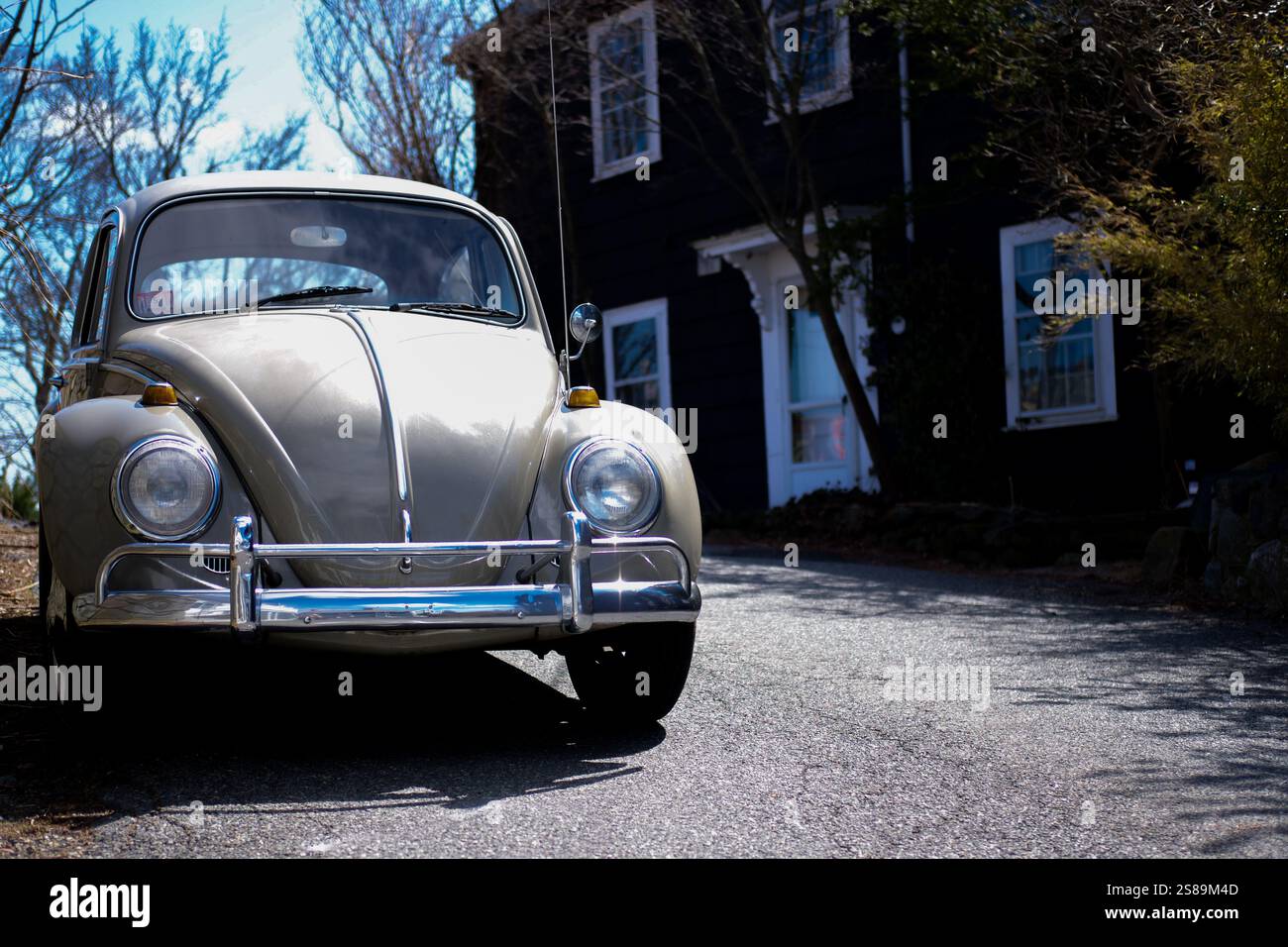 A classic Volkswagen Beetle parked outside a colonial home in ...