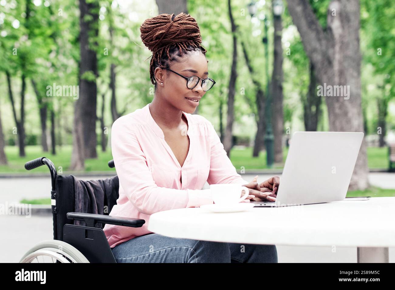 Remote job for people with disability. Young black woman in wheelchair ...