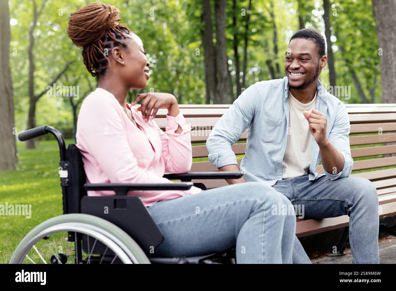 Positive handicapped black lady in wheelchair speaking to her boyfriend ...