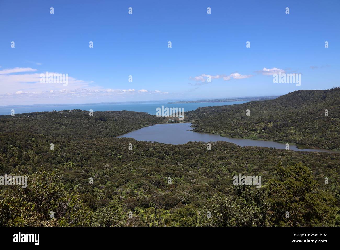 blue ocean waters and lush green forested hills under deep blue skies ...