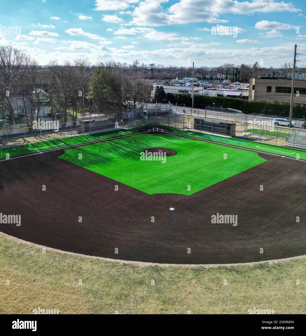 An aerial view captures a bright green artificial turf baseball field ...