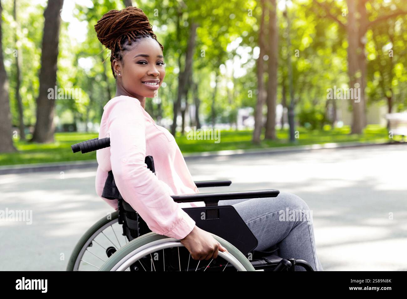 Positive handicapped black lady in wheelchair enjoying wonderful summer ...