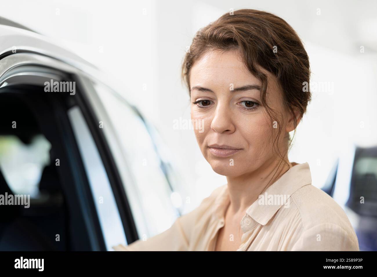 Customer in car dealership checking automobile features, comparing ...