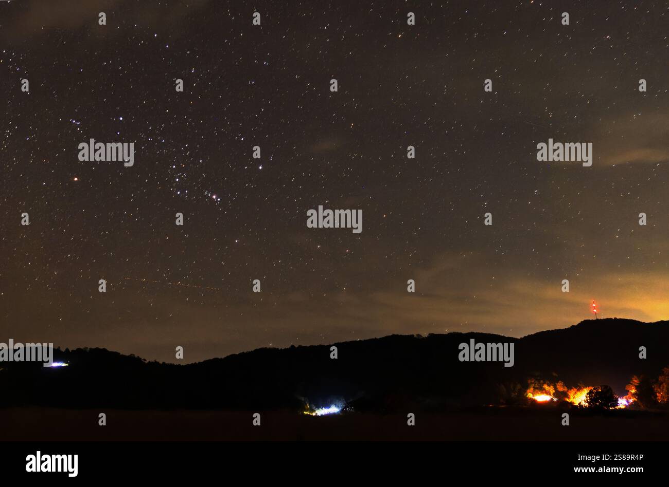 A breathtaking view of a star-filled night sky above a dark mountainous ...