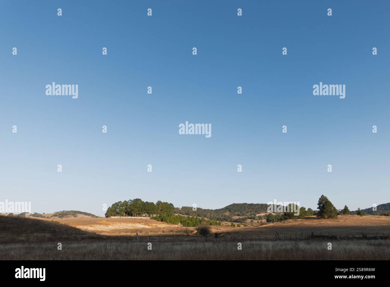 A wide view of a tranquil rural landscape showcases rolling hills and ...