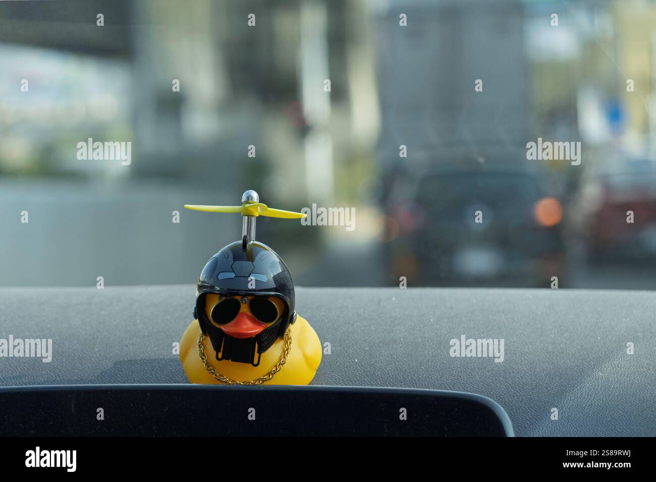A bright yellow rubber duck dressed in a black helmet and sunglasses ...